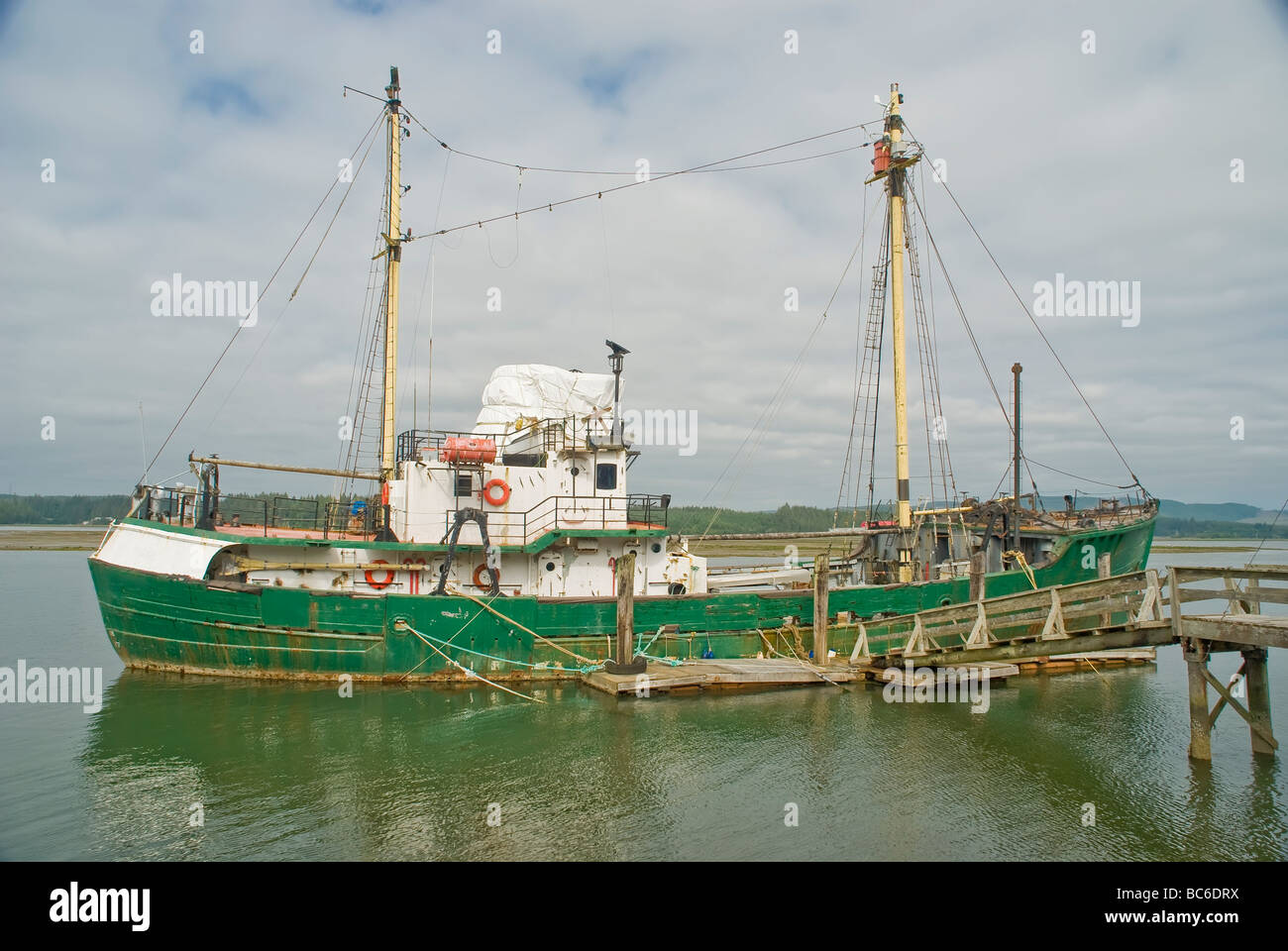 An old rotting wooden sailing ship is tied up at a dock Stock Photo - Alamy