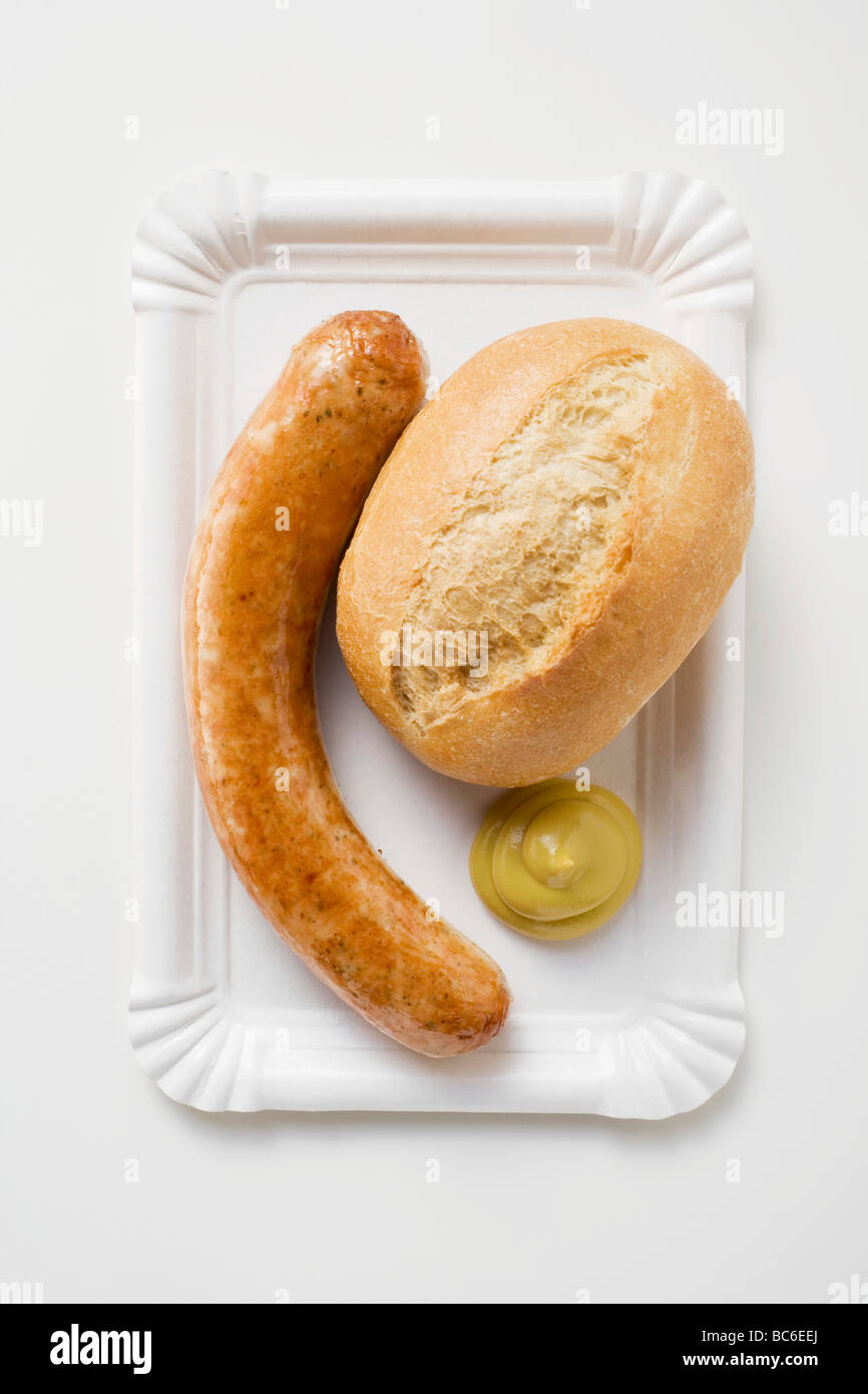 Sausage (bratwurst) with mustard & bread roll on paper plate Stock ...