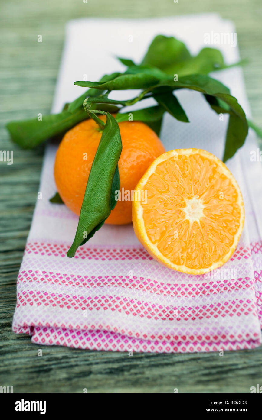 Whole clementine and half a clementine with leaves Stock Photo - Alamy