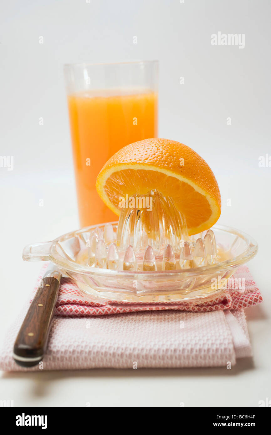 Squeezing an orange, glass of orange juice Stock Photo - Alamy