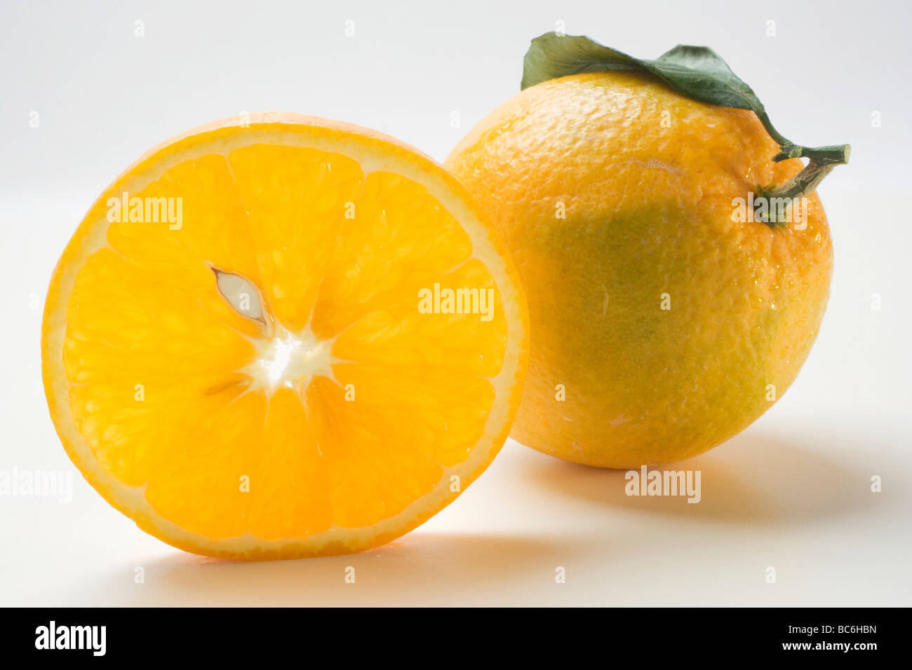 Slice of orange in front of whole orange Stock Photo - Alamy