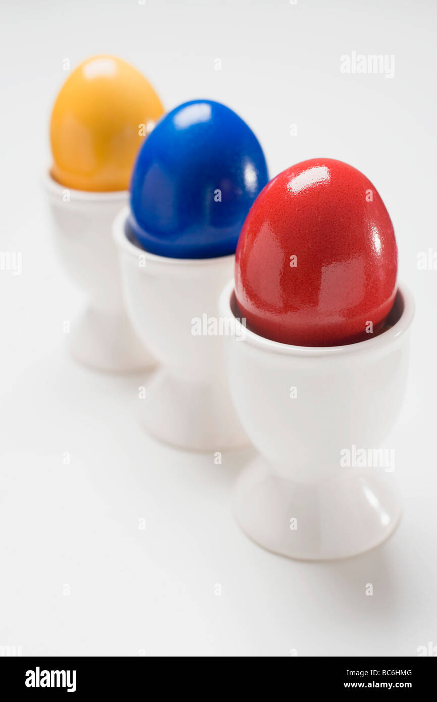 Three coloured eggs in egg cups Stock Photo - Alamy