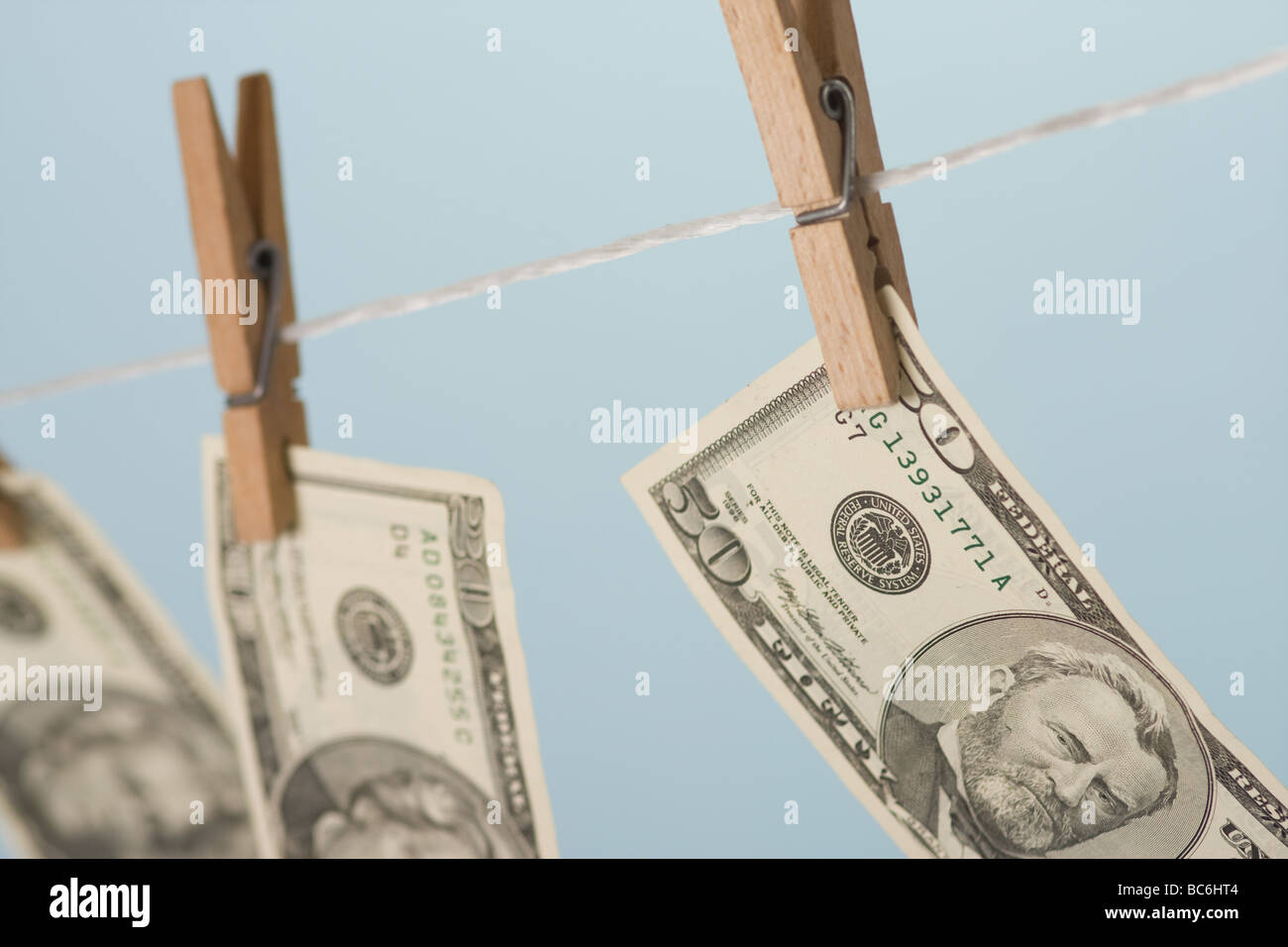 dollars hanging on line on blue background Stock Photo - Alamy