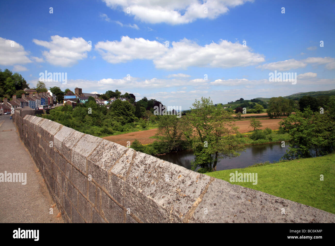 Stone bridge crossing the River Towy below the hillside town of ...