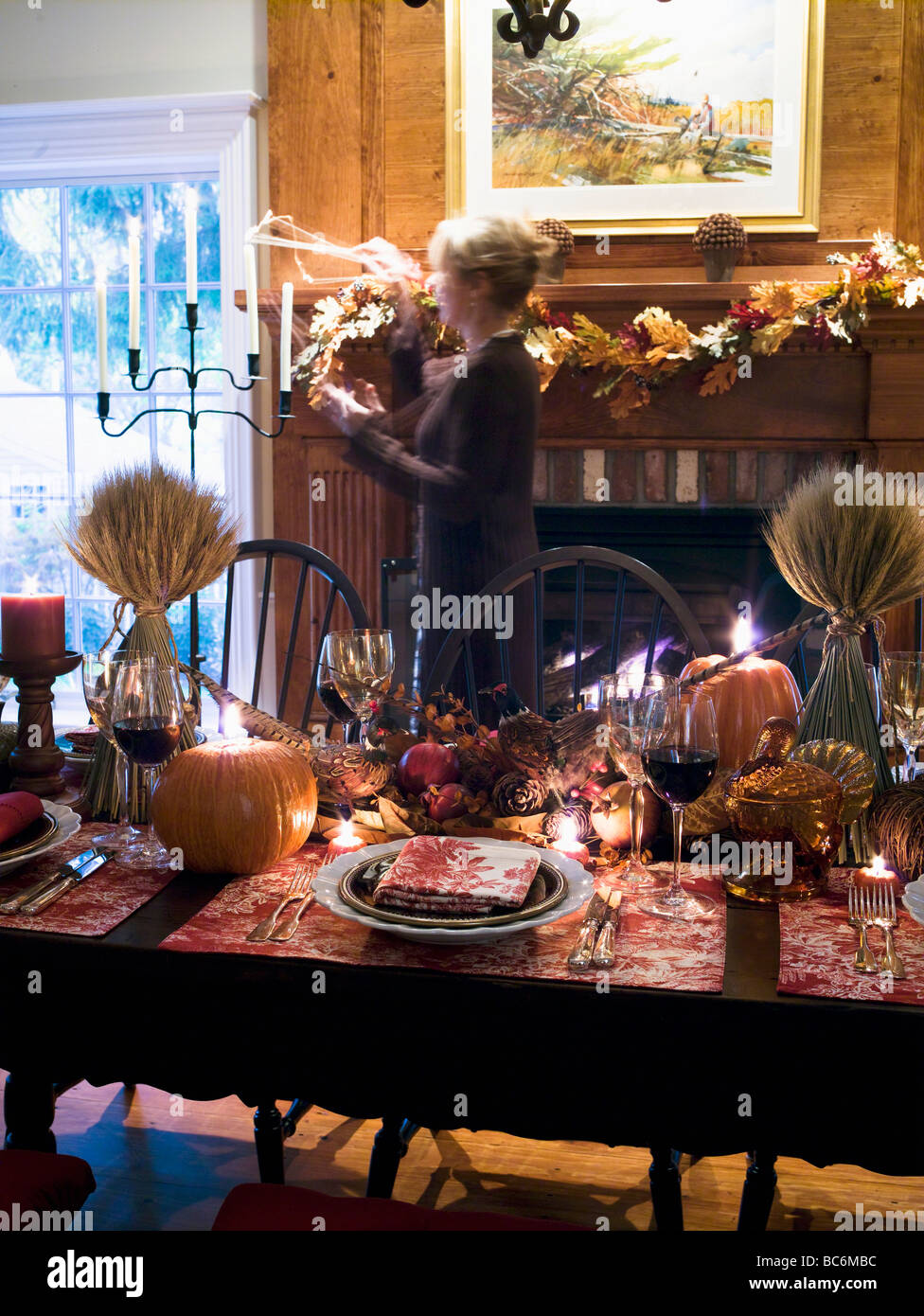 Table laid for Thanksgiving, woman in background (USA Stock Photo - Alamy