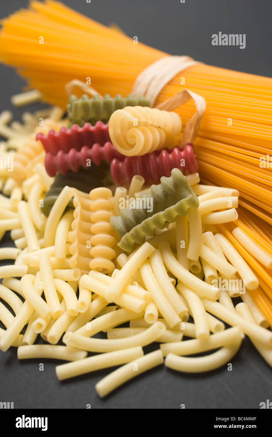 A bundle of spaghetti and various types of coloured pasta Stock Photo ...