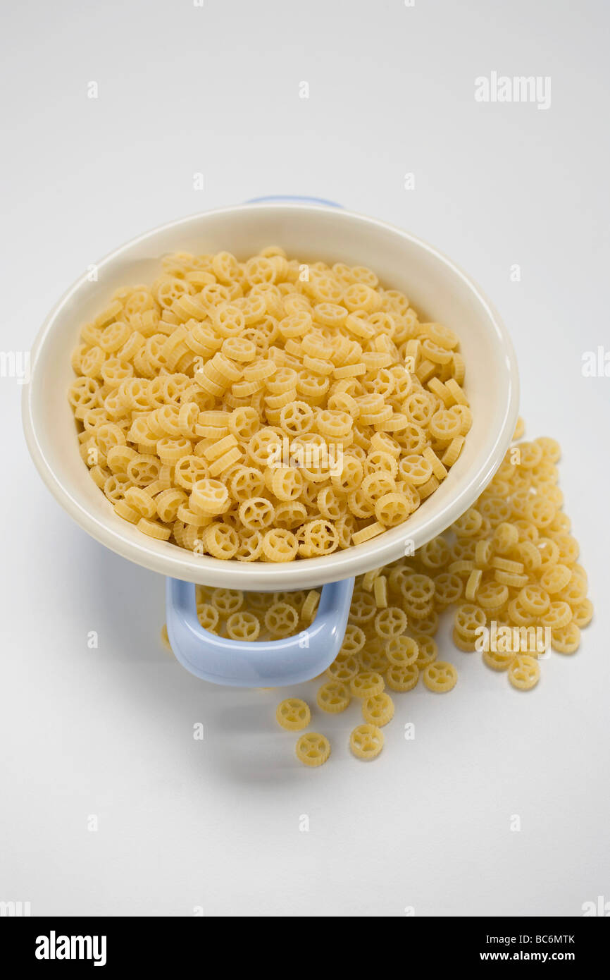 Wagon wheel pasta, partly in strainer Stock Photo - Alamy
