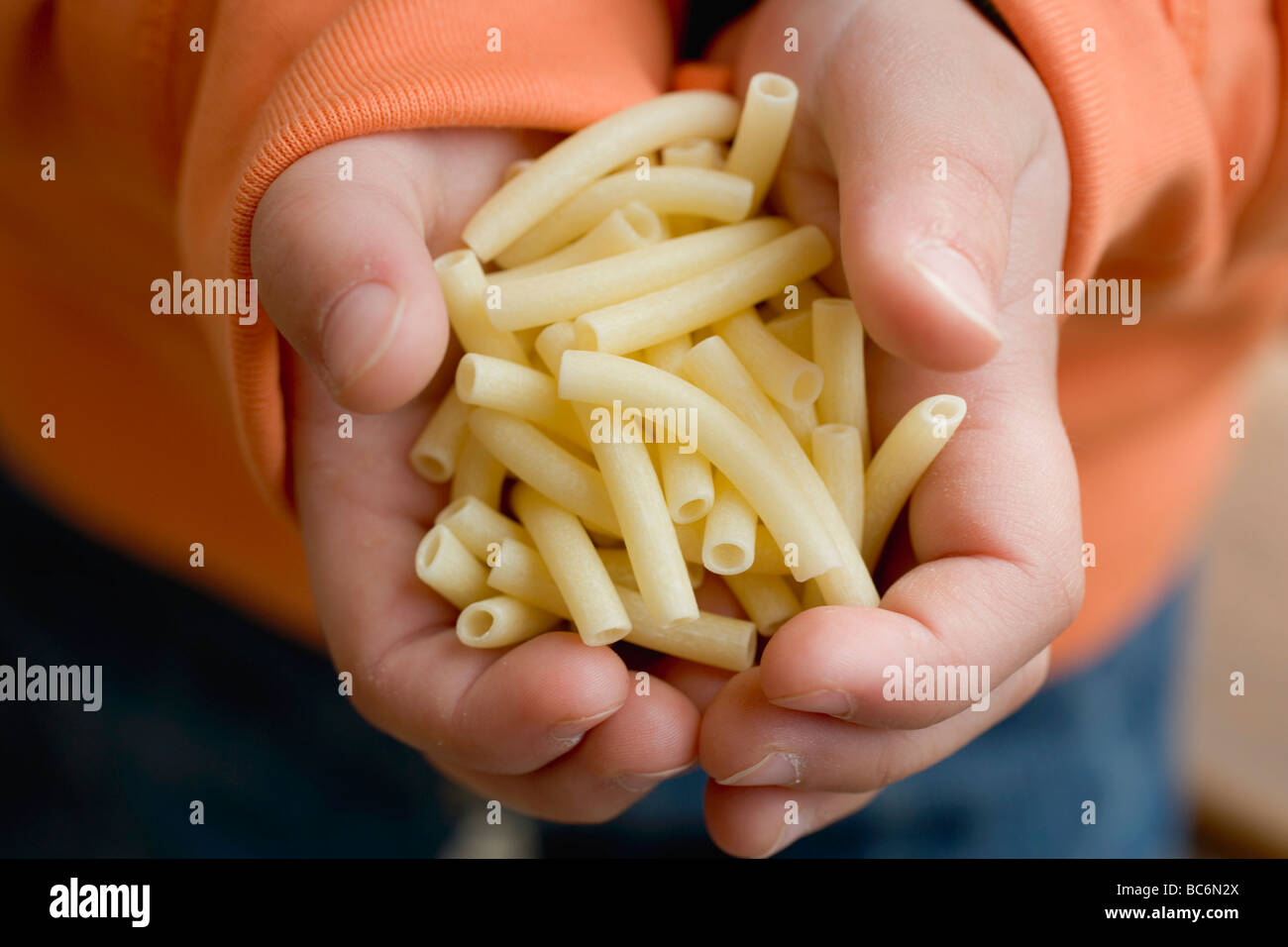 Child's hands holding macaroni Stock Photo - Alamy