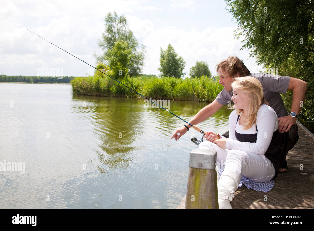 Father is teaching his daughter how to catch a fish Stock Photo - Alamy