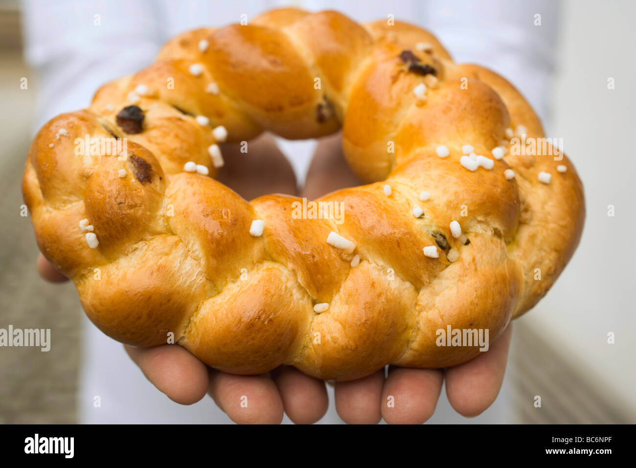 Hands holding plaited bread ring with pearl sugar (Easter Stock Photo ...