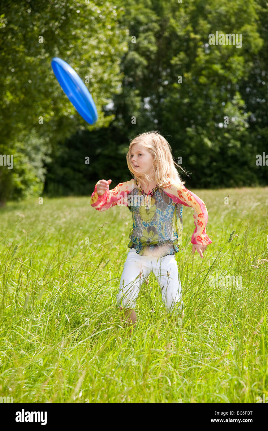 Young five year old girl throwing a frisbee in the field Stock Photo ...