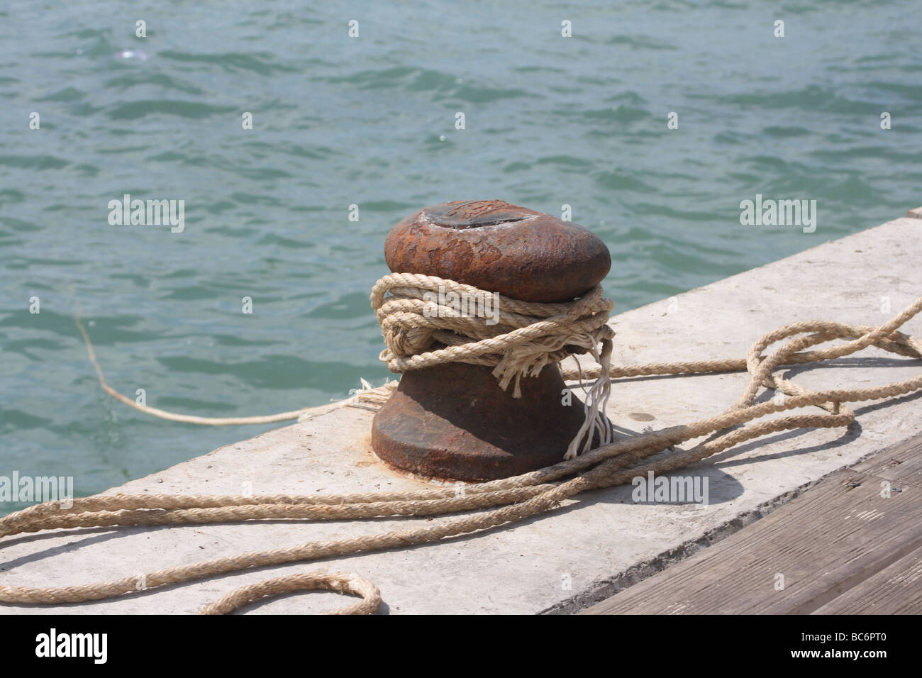 rusty metal mooring bollard with rope on a pier Stock Photo - Alamy
