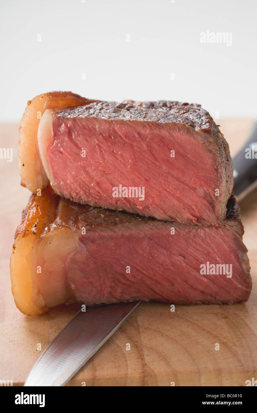 Beef steak with fatty edge, cut in two Stock Photo - Alamy