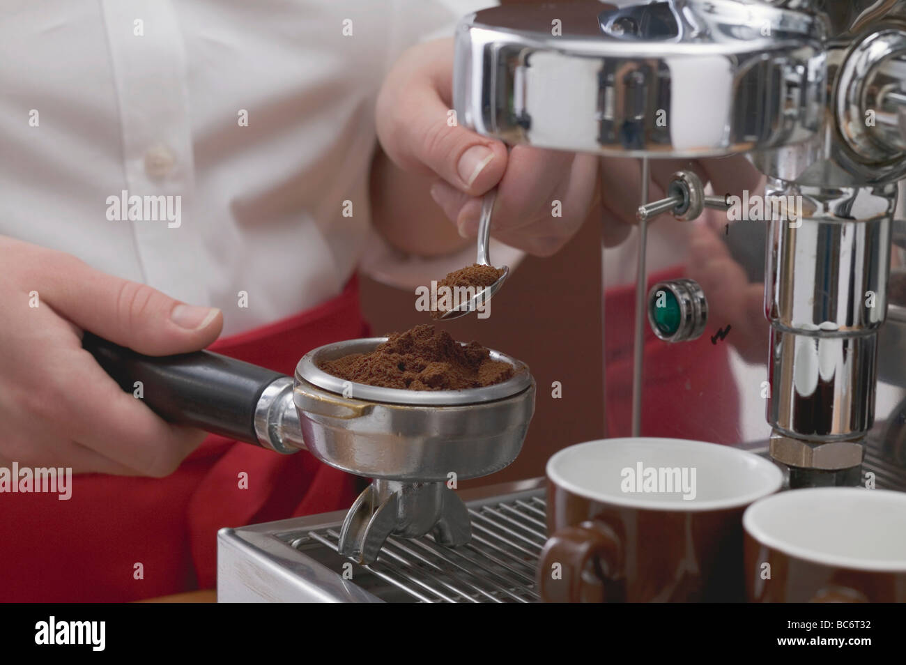 Woman filling filter holder with ground espresso coffee Stock Photo - Alamy