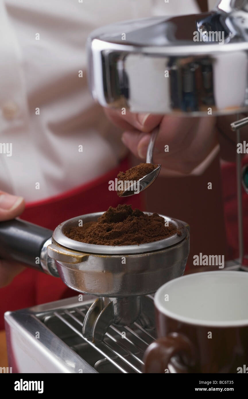 Woman filling filter holder with ground espresso coffee Stock Photo - Alamy