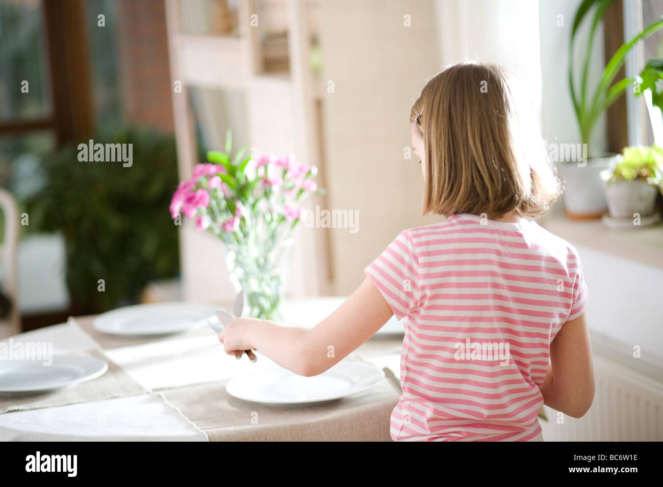 Girl laying the table Stock Photo - Alamy