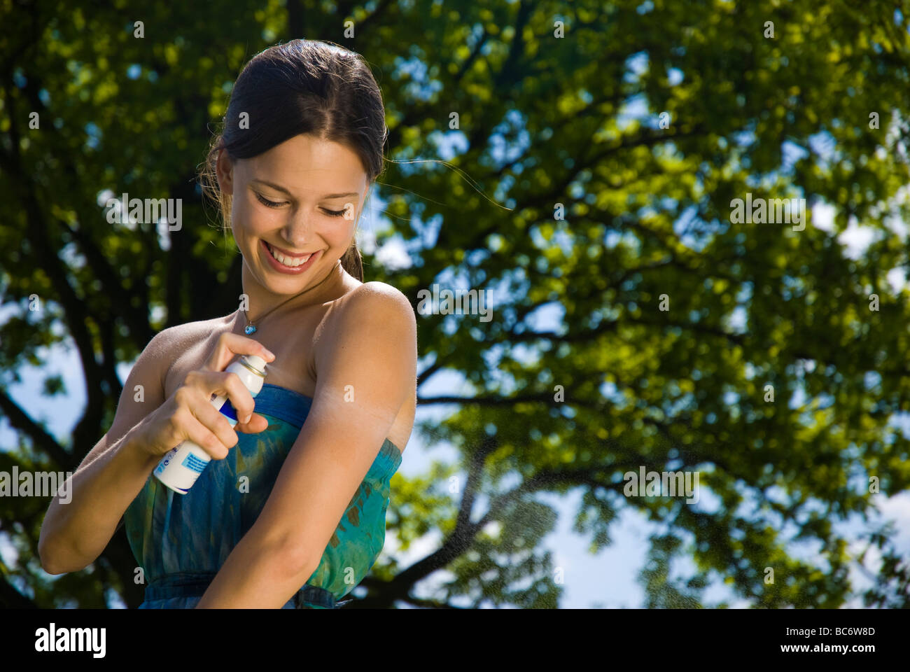 Young woman using spray for mosquitoes Stock Photo - Alamy