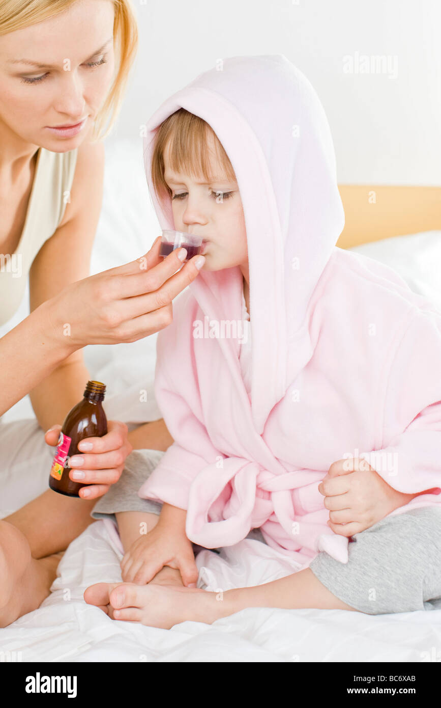 mother giving syrup to baby Stock Photo - Alamy