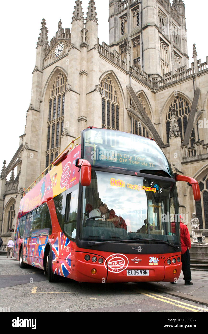 A MODERN OPEN TOP RED TOUR BUS IN FRONT OF THE OLD BATH ABBEY IN ...