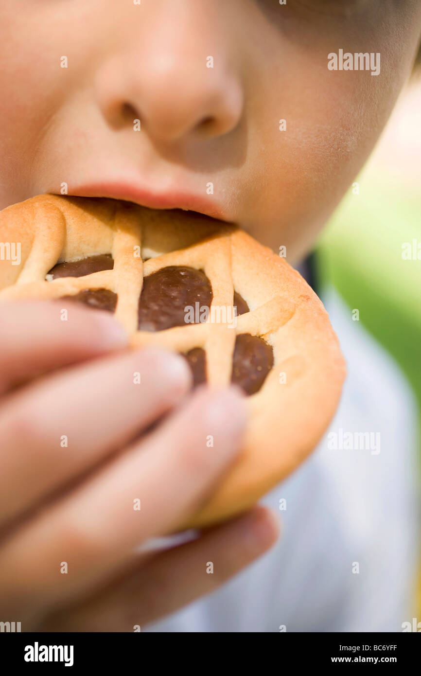 Child biting into chocolate tartlet Stock Photo - Alamy