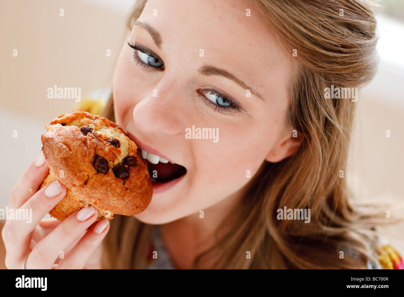 woman biting into a chocolate chip muffin Stock Photo - Alamy