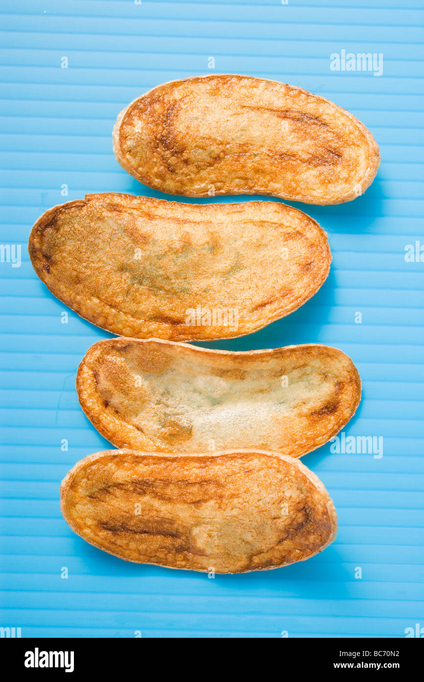 Four home-made potato crisps on blue background Stock Photo - Alamy