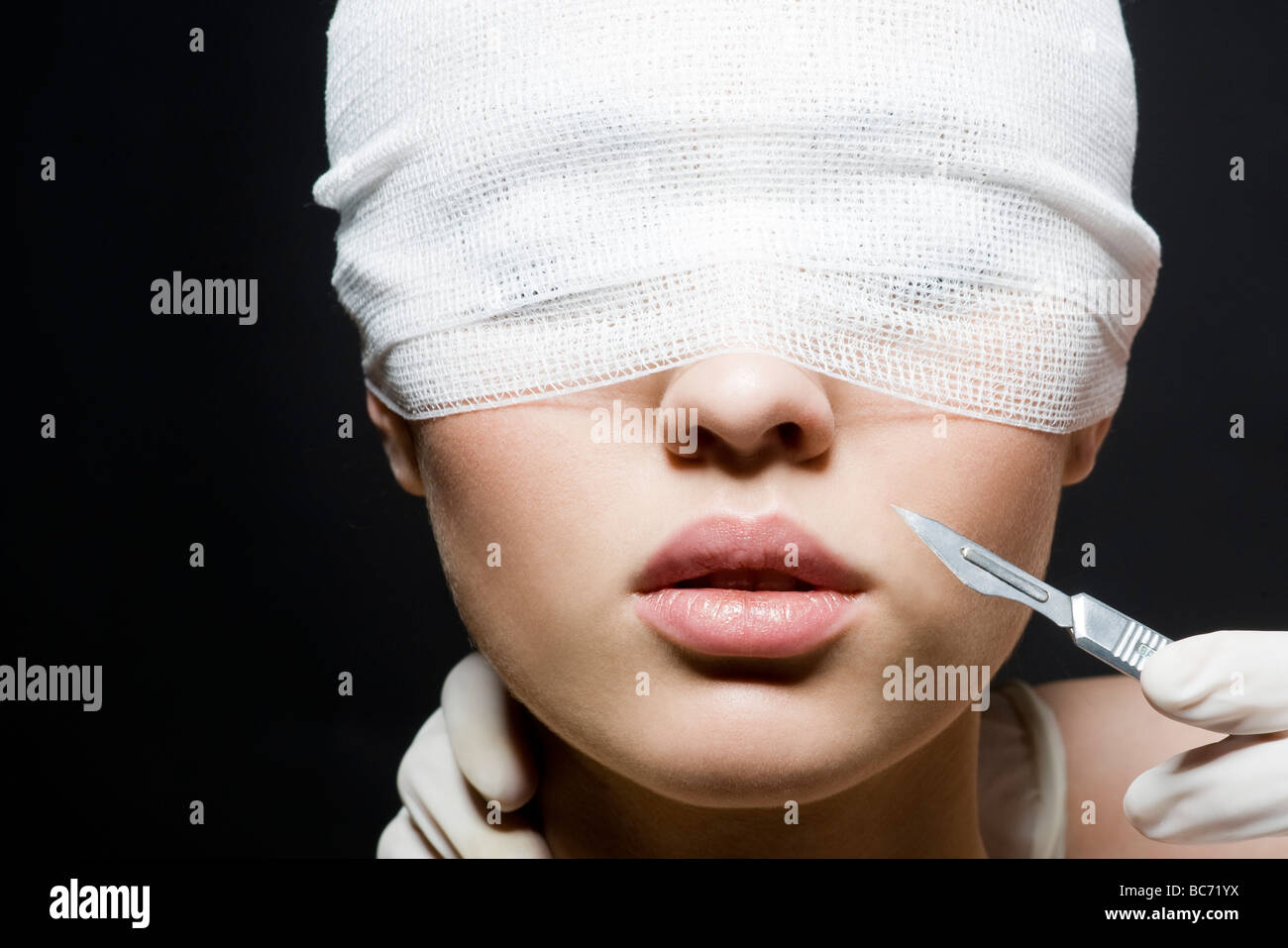 Hand holding a scalpel in front of face Stock Photo - Alamy