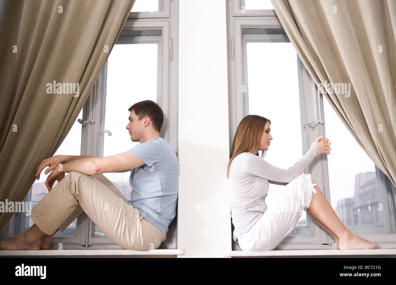 couple sitting apart in flat Stock Photo - Alamy