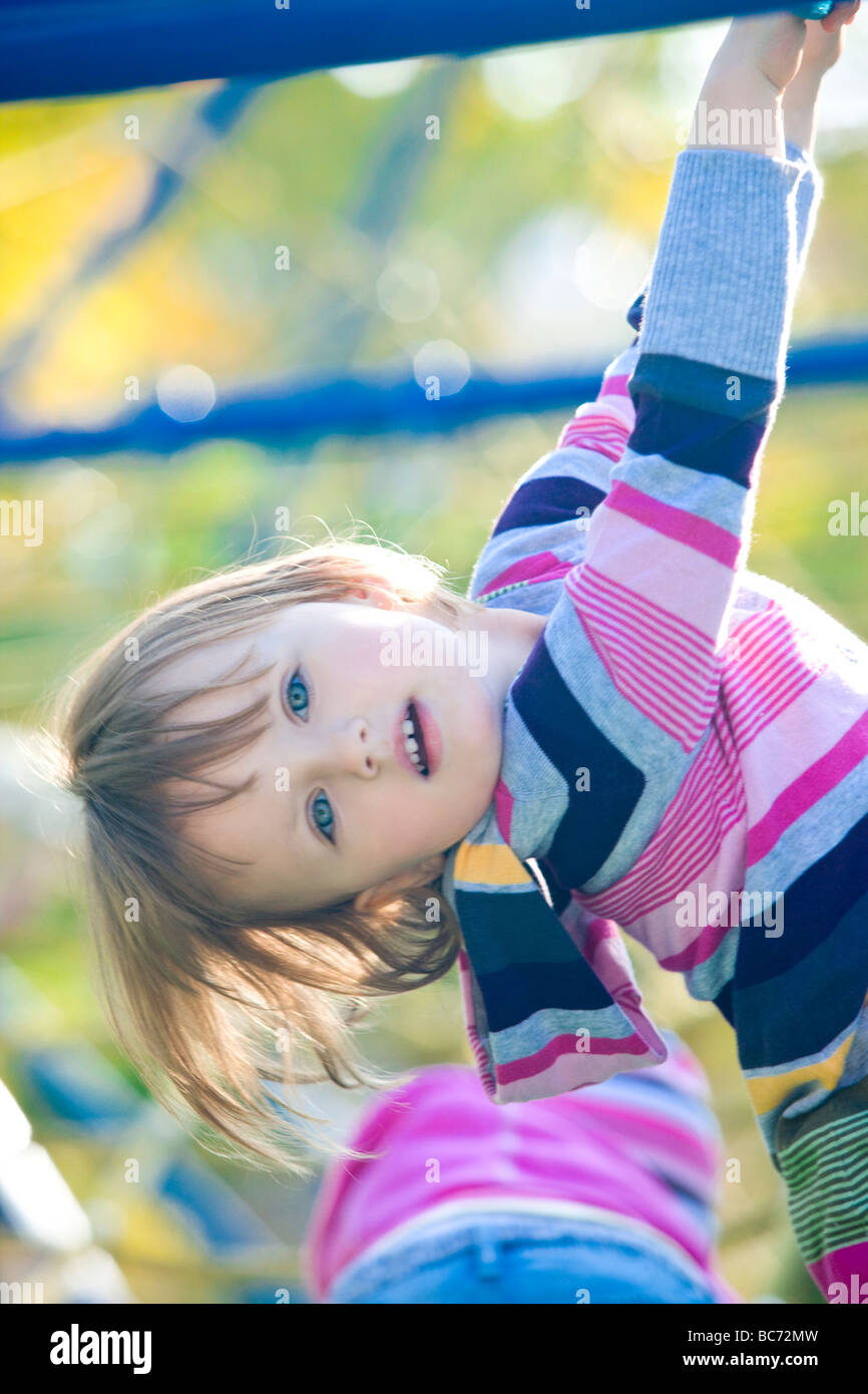 girl playing on a climbing frame Stock Photo - Alamy