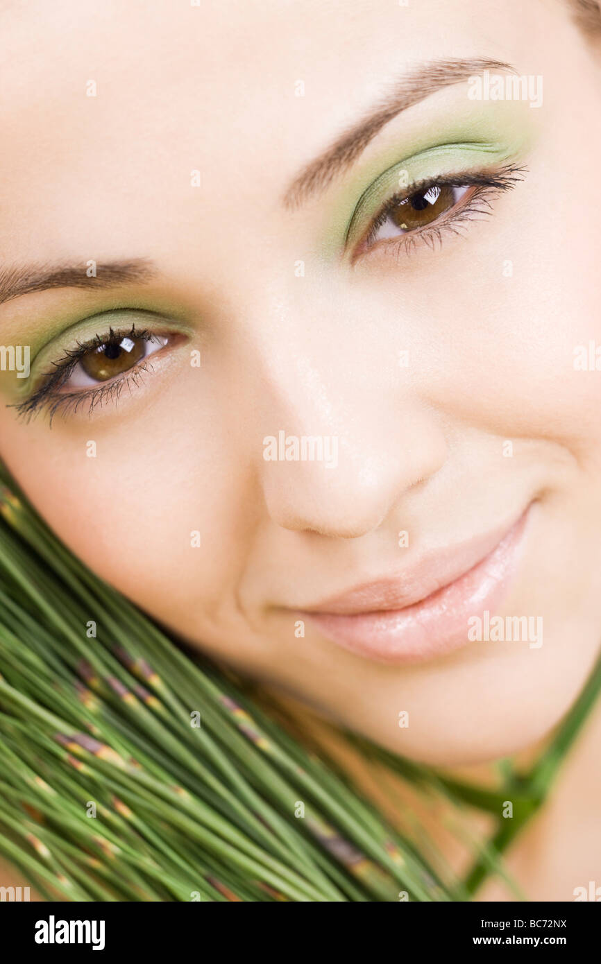 woman with green makeup and plant next to face Stock Photo - Alamy