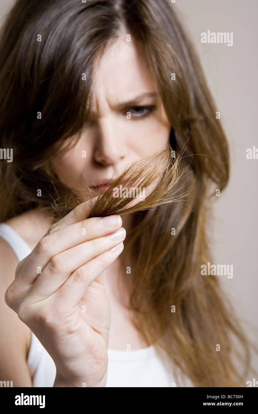 woman looking at hair ending Stock Photo - Alamy
