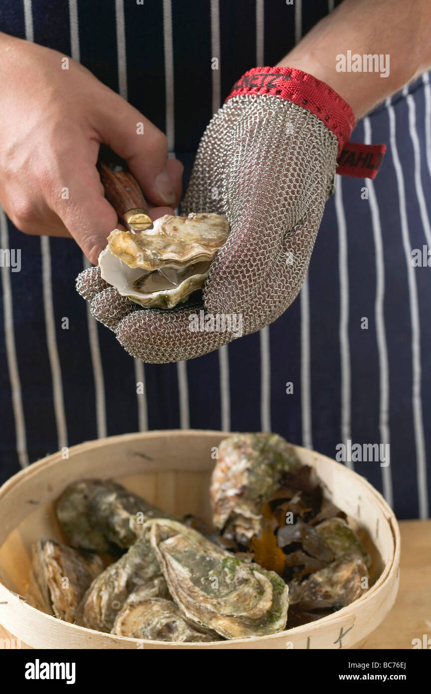Shucking oysters Stock Photo - Alamy