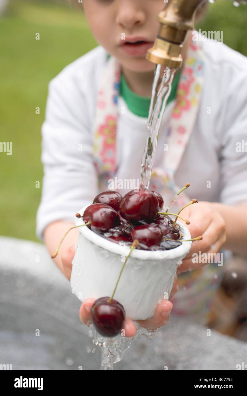 Child washing cherries under tap Stock Photo - Alamy
