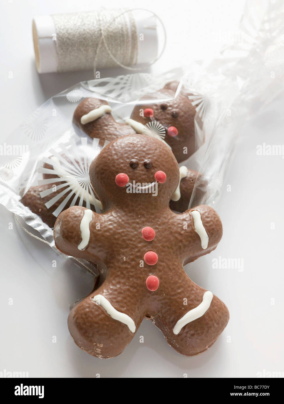 Two chocolate-coated gingerbread men, one in cellophane bag Stock Photo ...