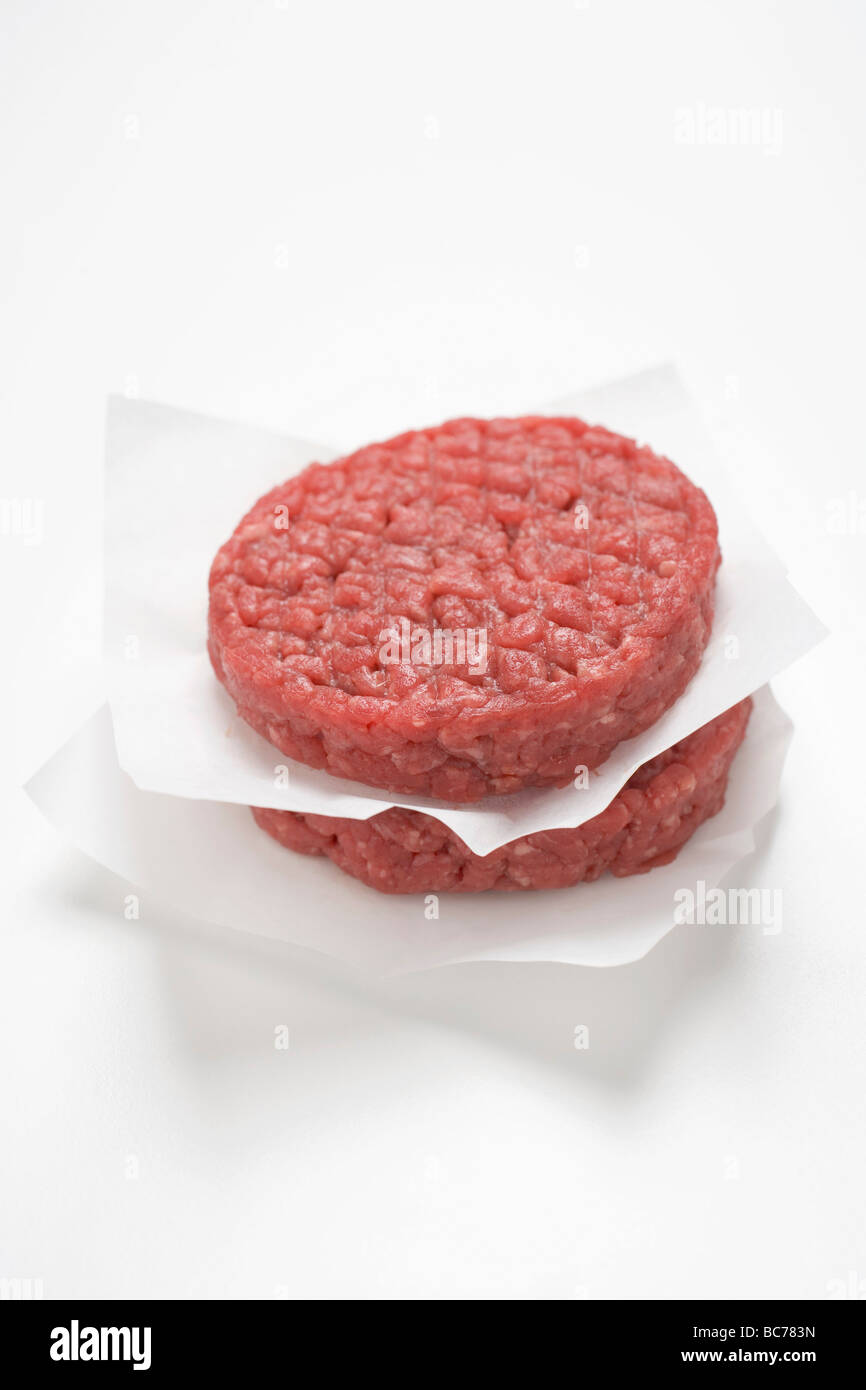 Two raw burgers on paper Stock Photo - Alamy