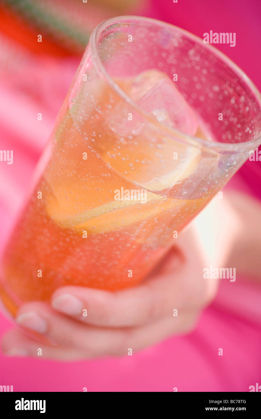 Hand holding a glass of iced tea Stock Photo - Alamy