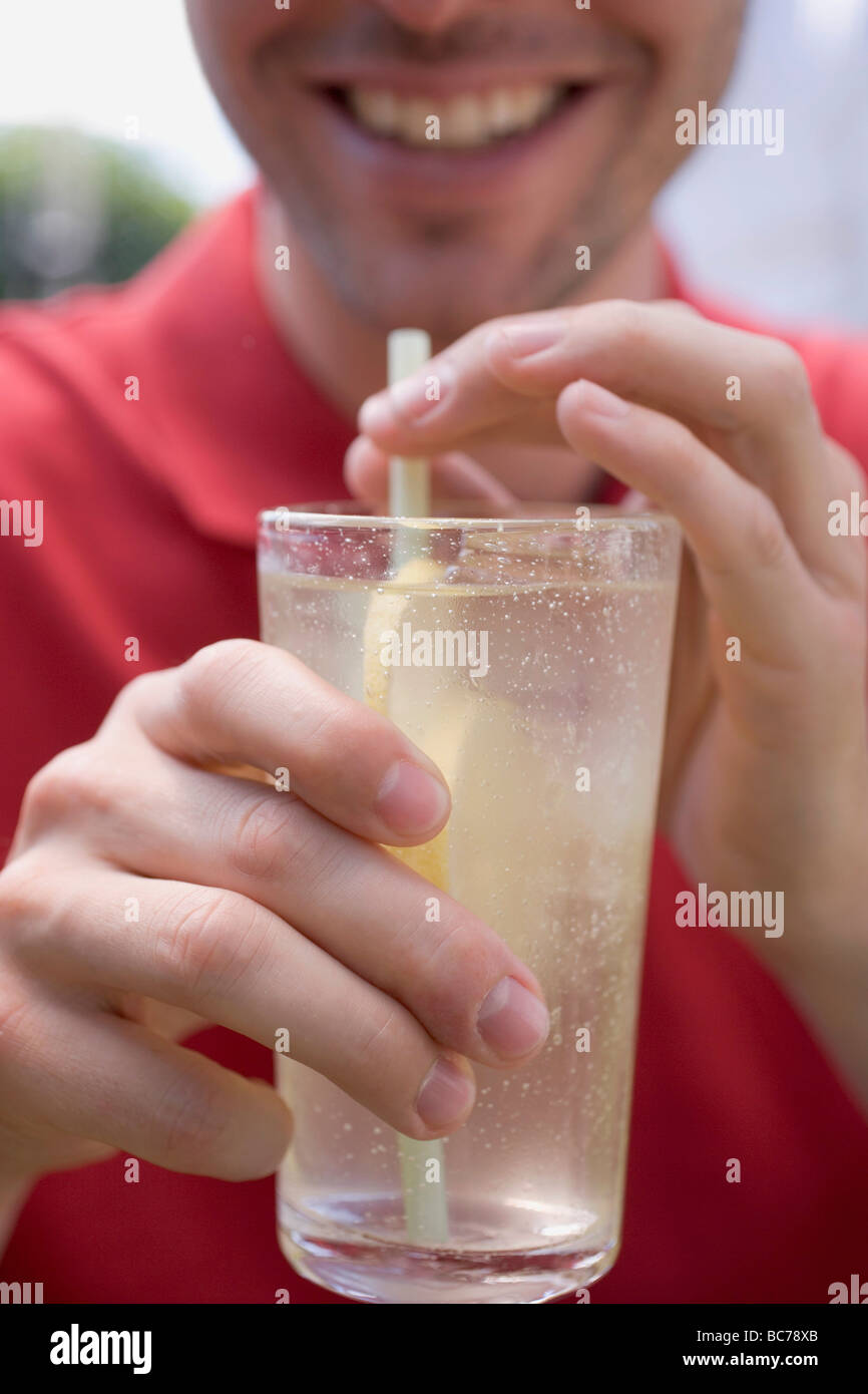 Man holding glass of lemonade with straw Stock Photo - Alamy