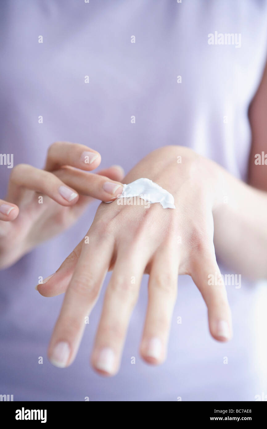 Woman applying cream to hands, close-up Stock Photo - Alamy