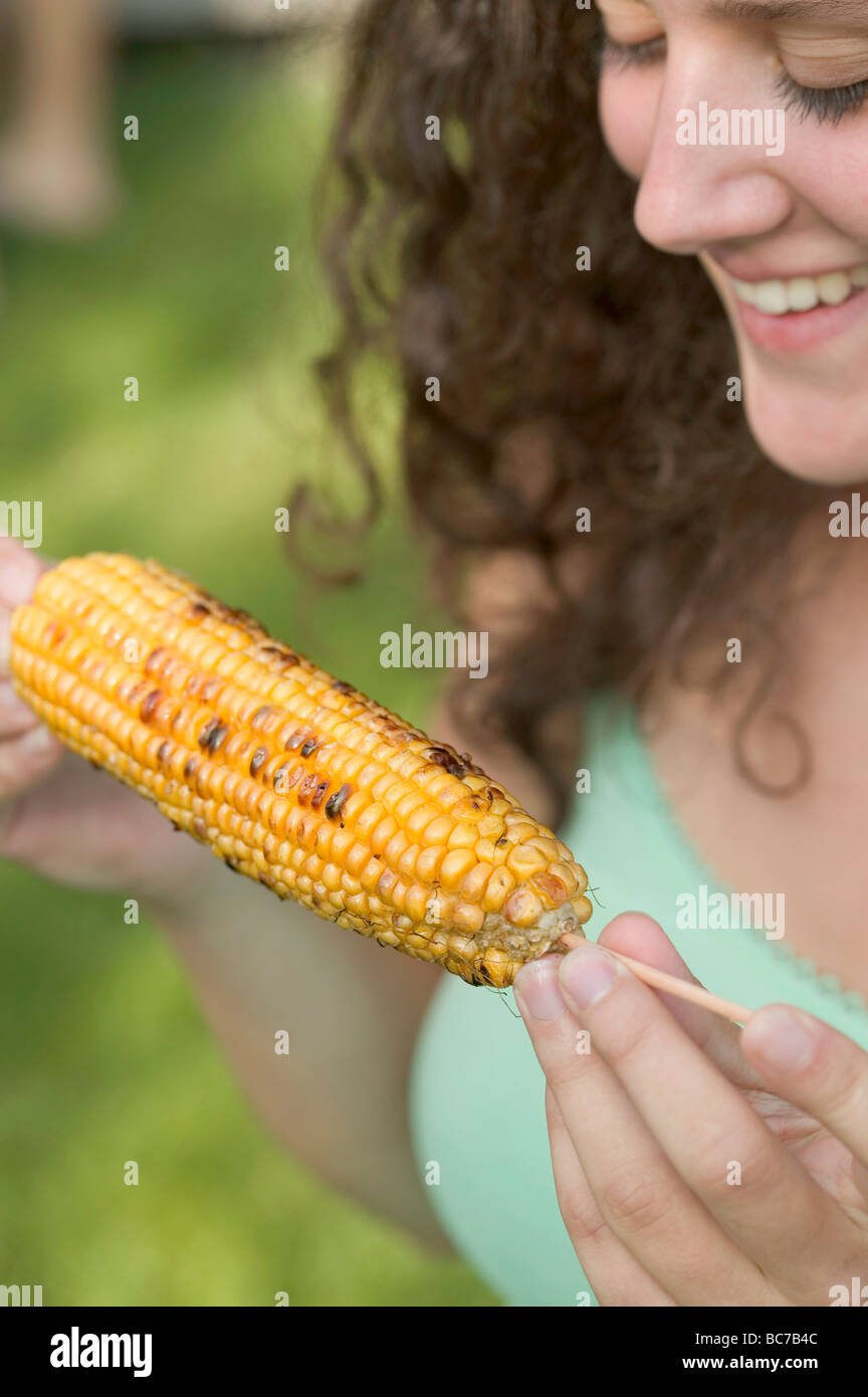 Woman holding grilled corn on the cob Stock Photo - Alamy