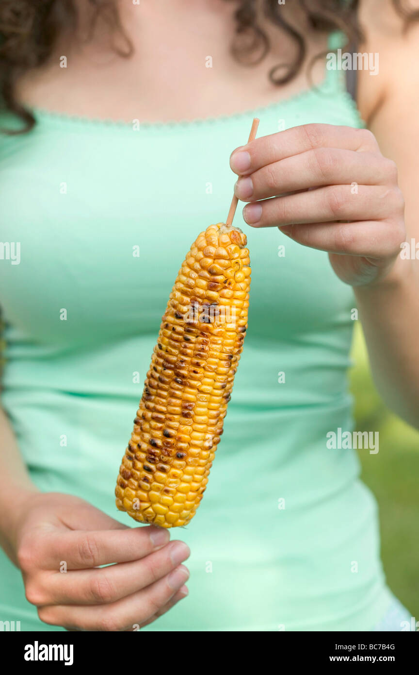 Woman holding grilled corn on the cob Stock Photo - Alamy
