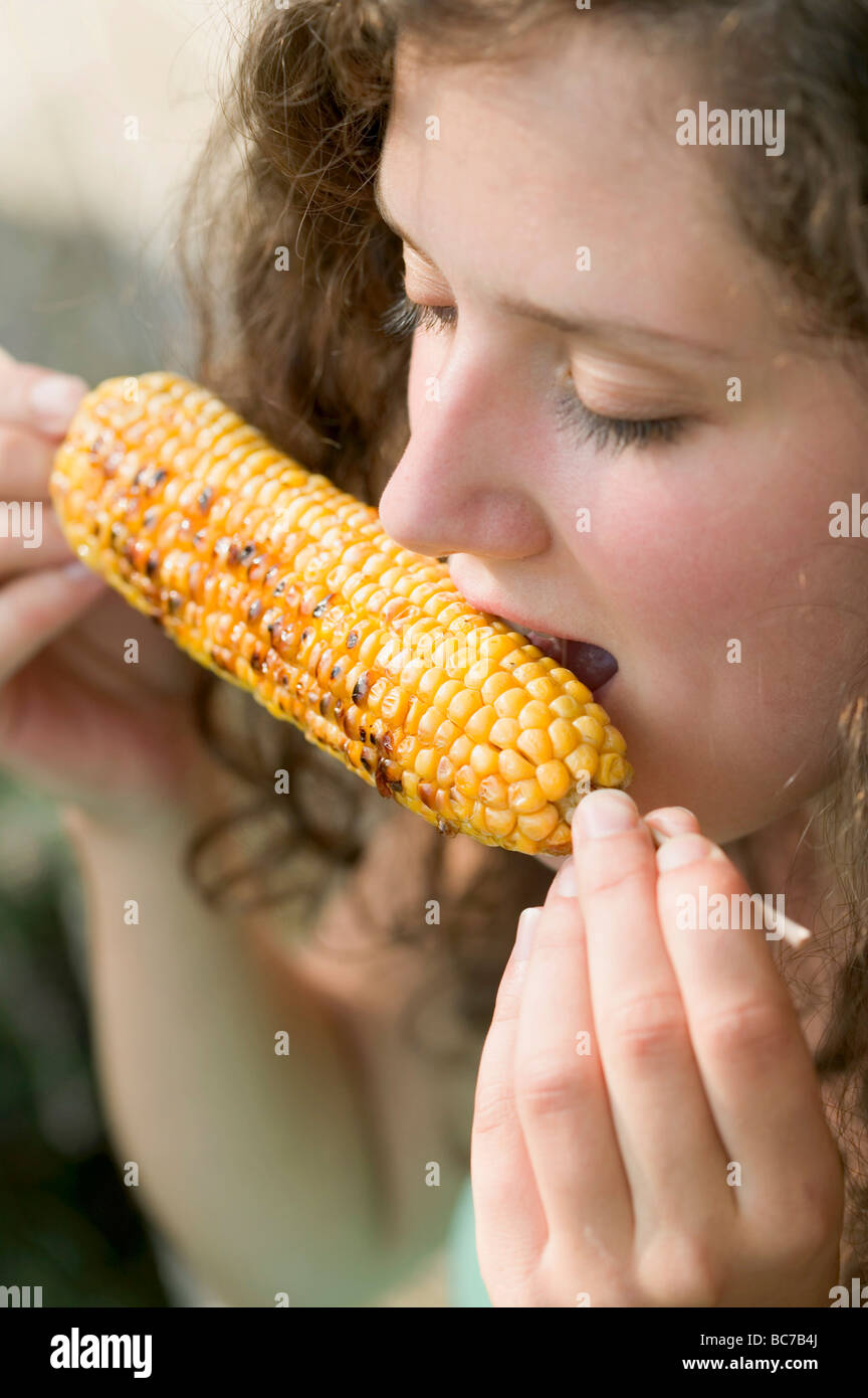 Woman eating grilled corn on the cob Stock Photo - Alamy