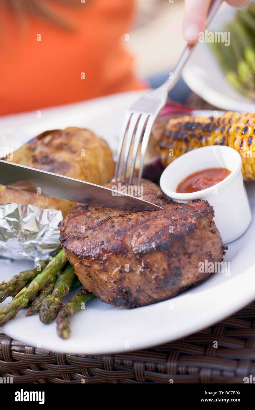 Person eating grilled beef steak Stock Photo - Alamy