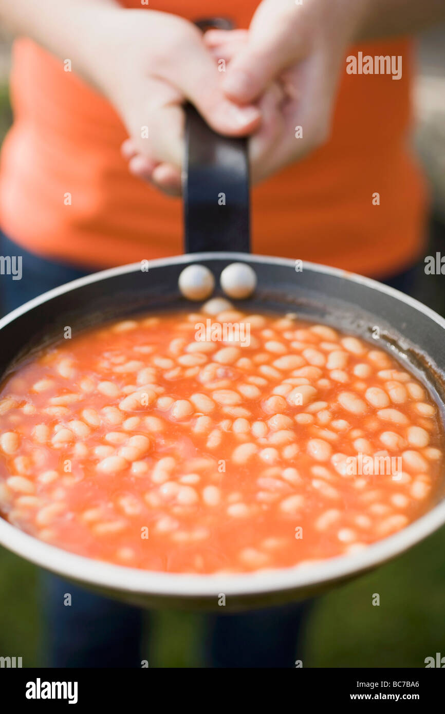 Person holding a pan of baked beans Stock Photo - Alamy