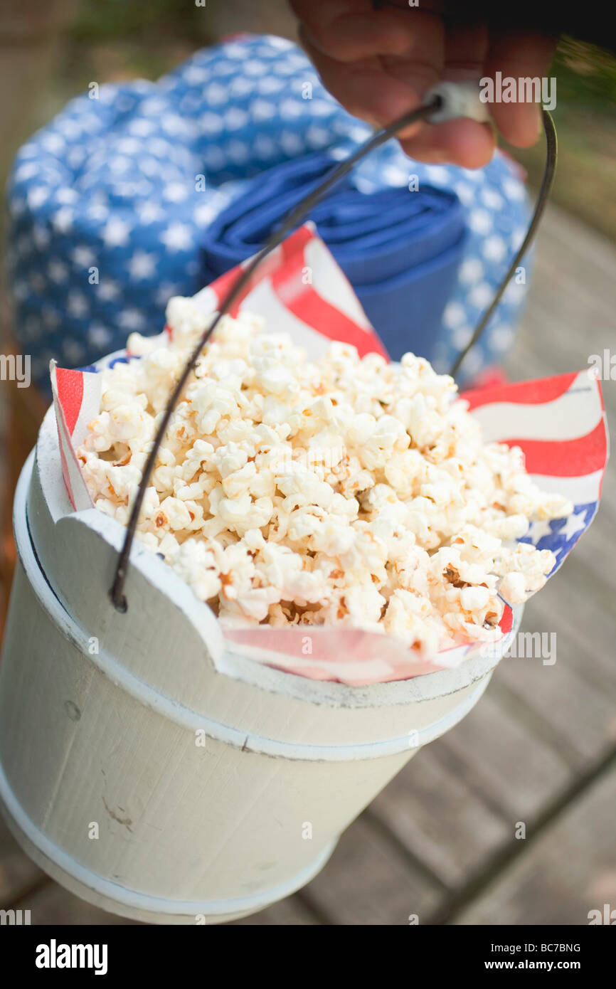 Hand holding wooden bucket full of popcorn (4th of July, USA Stock ...