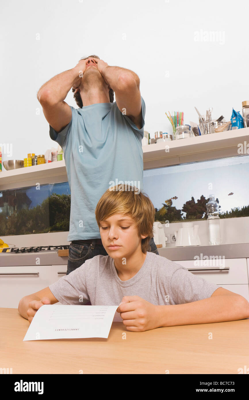 Father and son (13-14), Boy with report card, Man covering eyes Stock ...