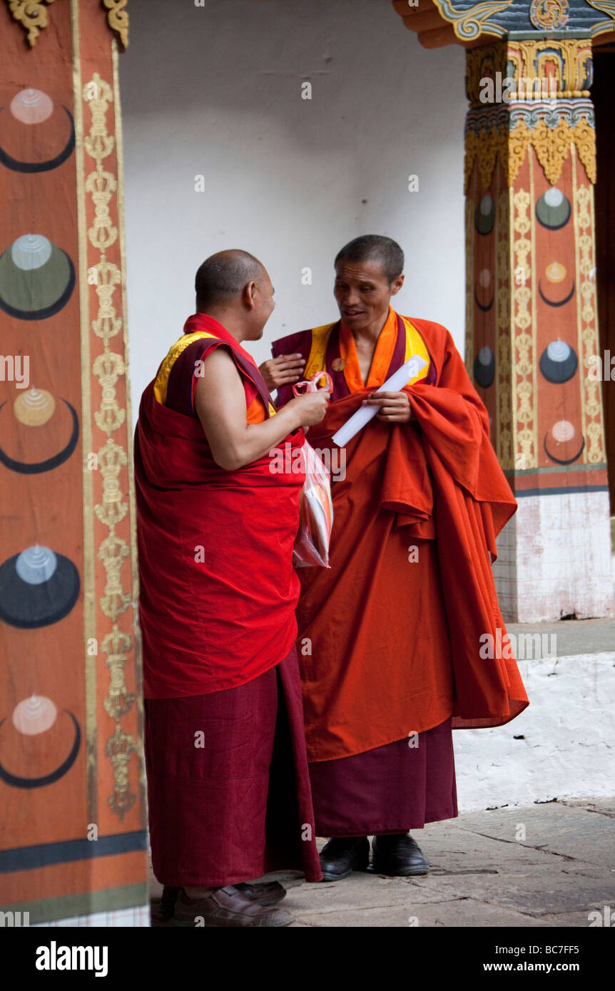 Two Monks students in red habit chatting with scroll at Punakha Dzong ...