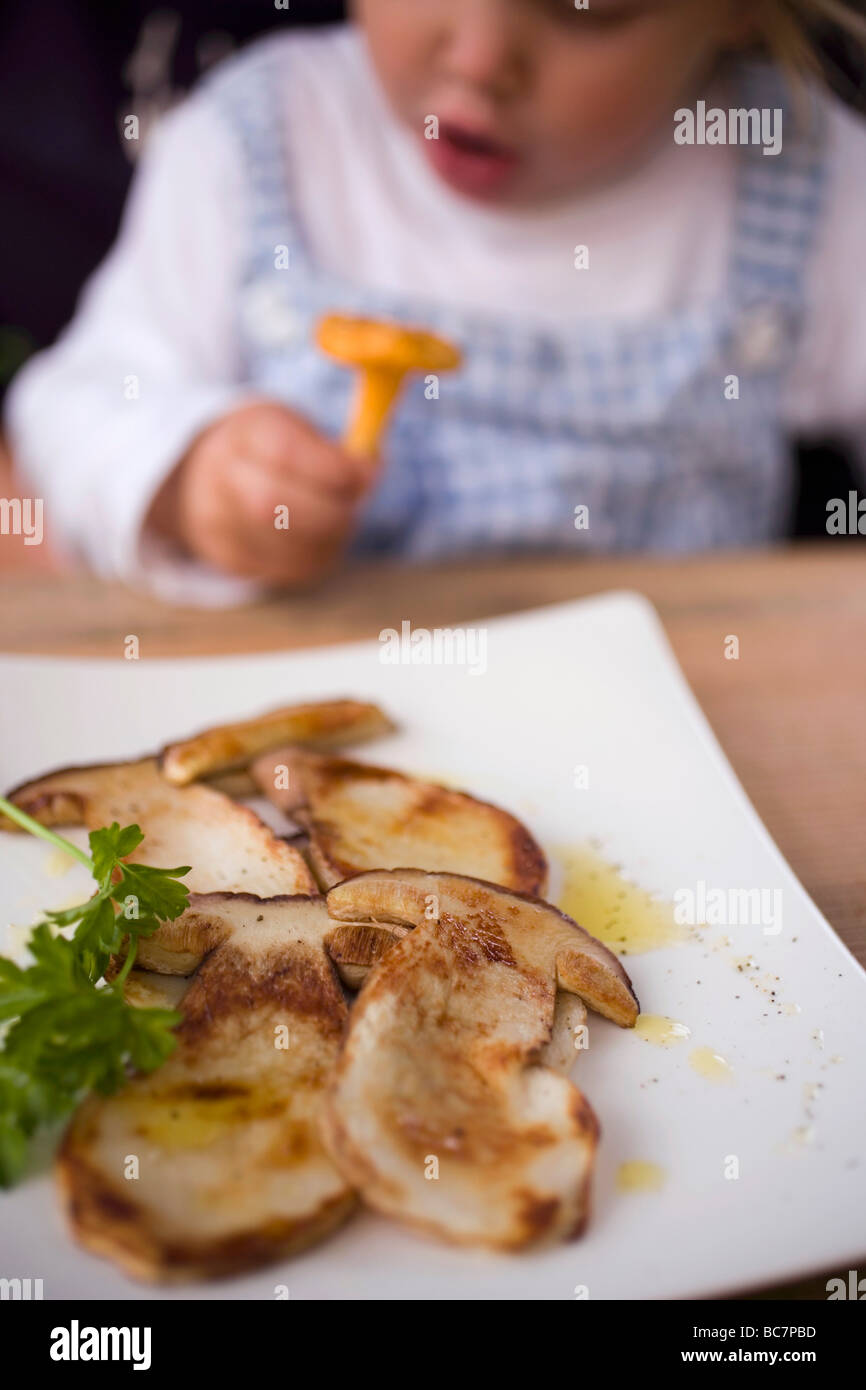 Fried cep slices, child with chanterelle behind Stock Photo - Alamy