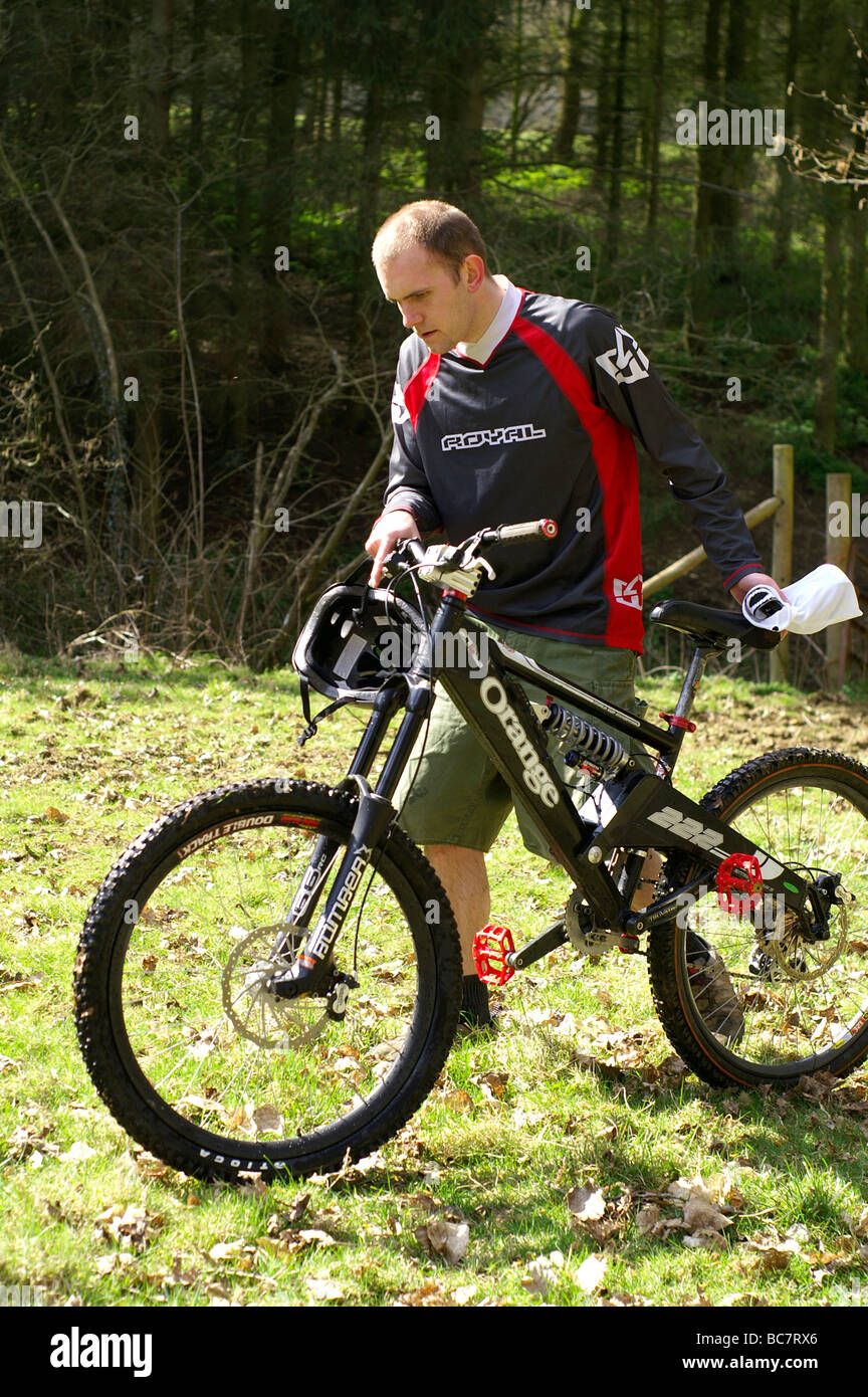 Downhill rider pushing his mountain bike Stock Photo - Alamy