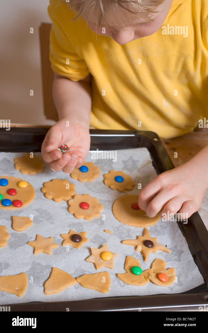 Child decorating biscuits with coloured chocolate beans Stock Photo - Alamy