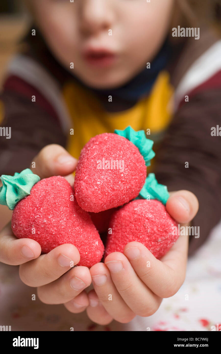 Child's hands holding marzipan strawberries Stock Photo - Alamy